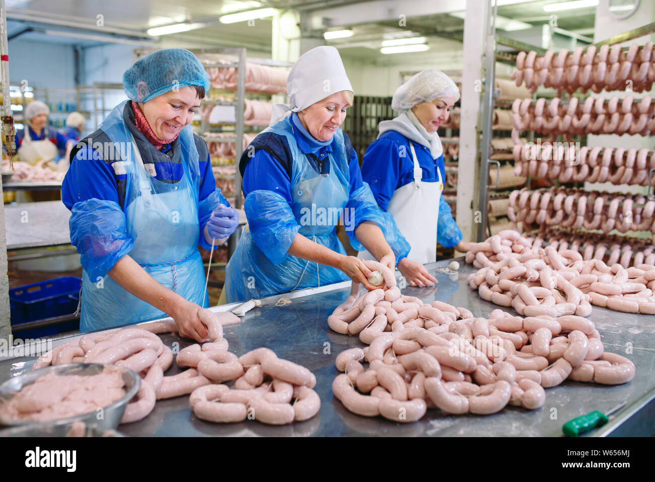 Butchers processing sausages at the meat factory Stock Photo - Alamy