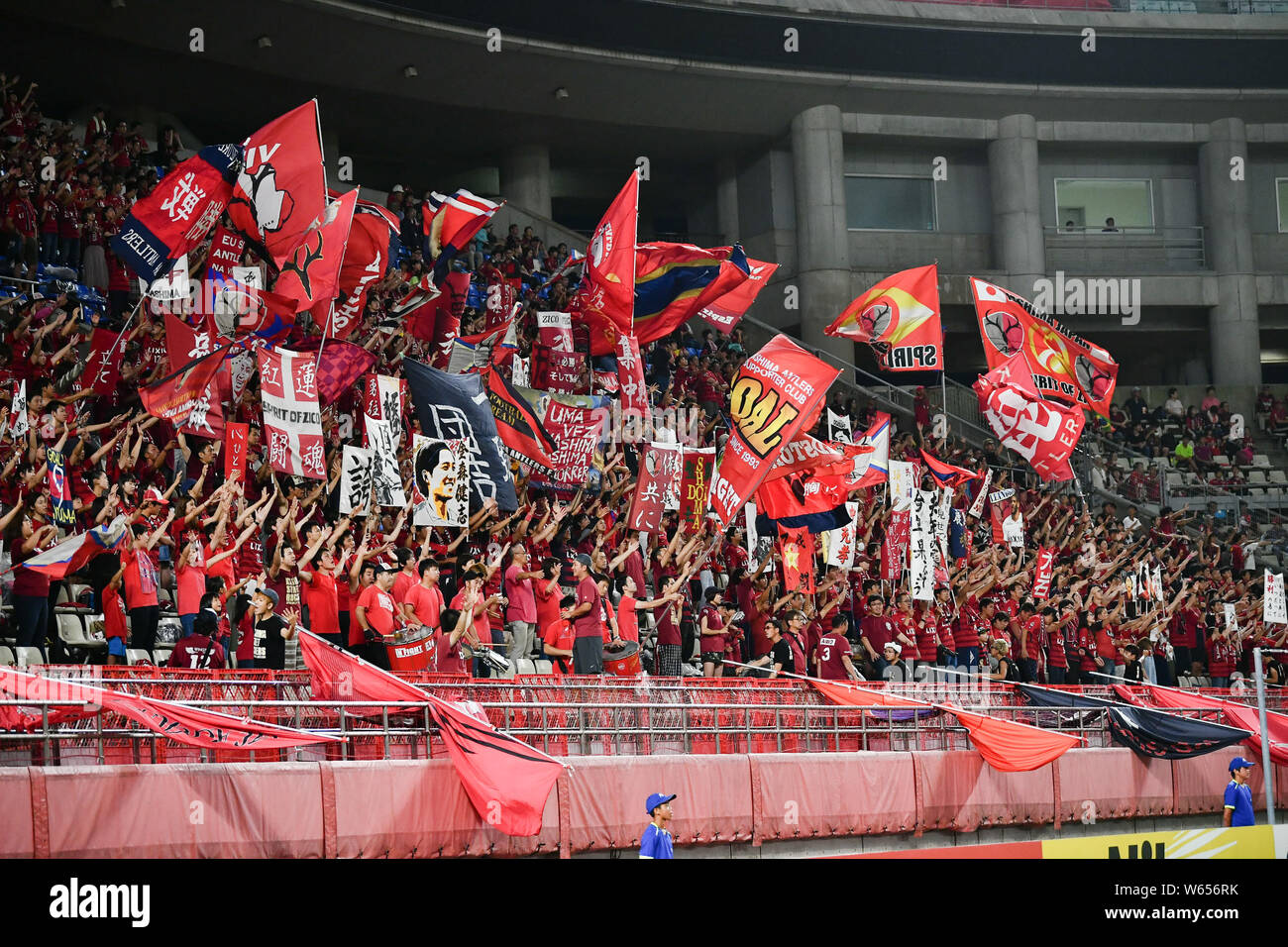 Football fans wave flags and shout slogans to show support for Japan's Kashima Antlers in the ...