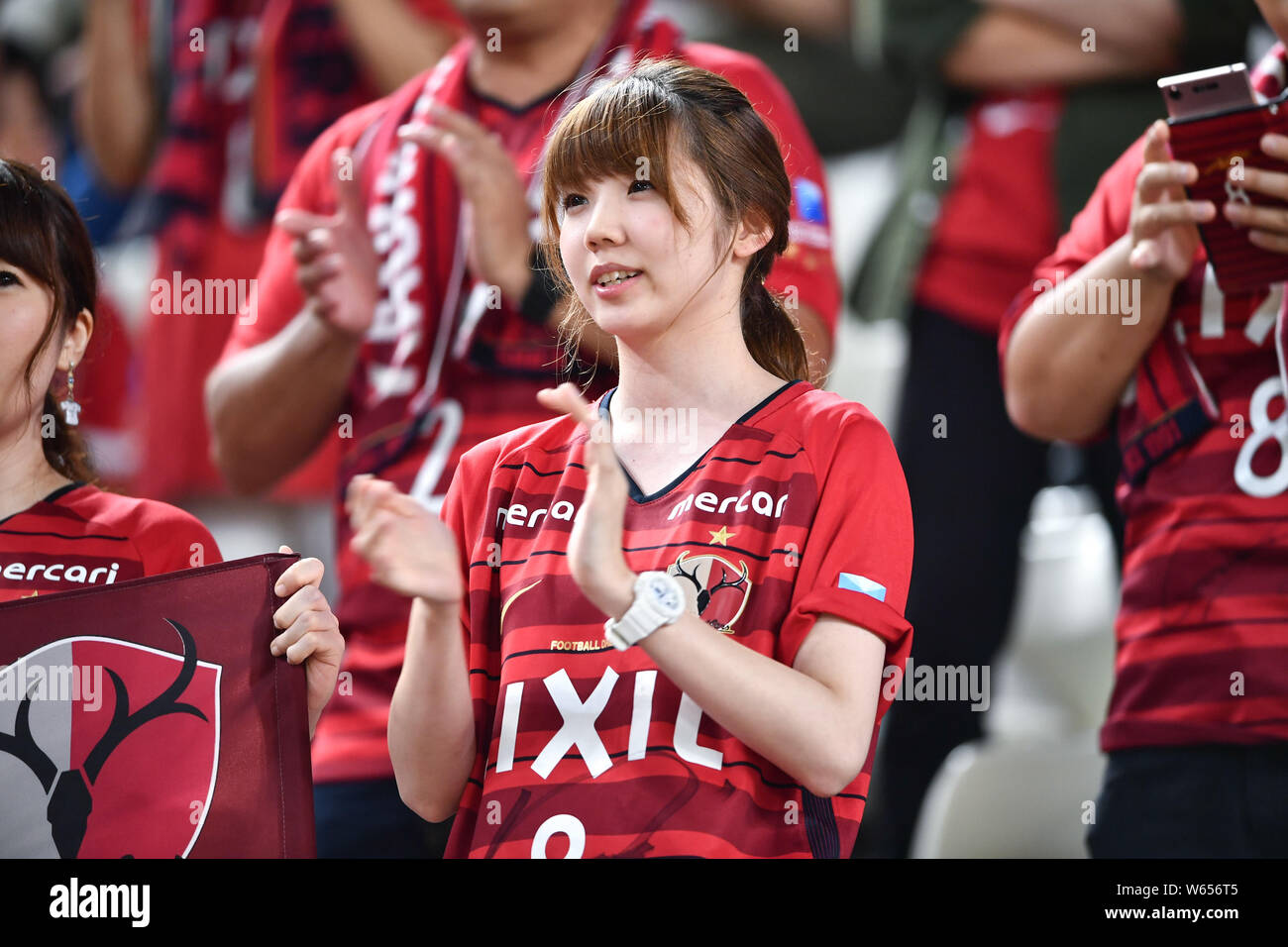 Football fans wave flags and shout slogans to show support for Japan's Kashima Antlers in the ...