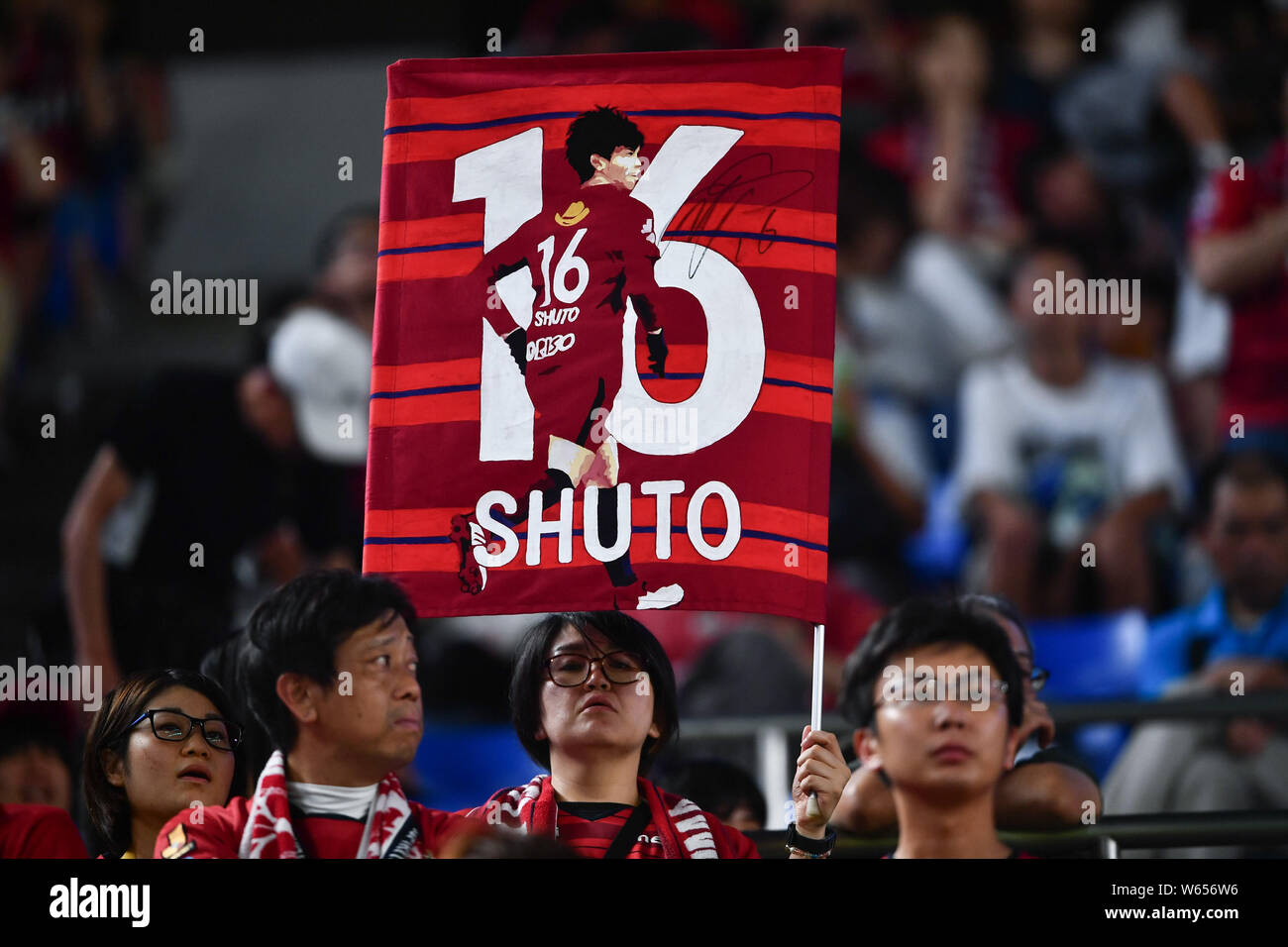 Football fans wave flags and shout slogans to show support for Japan's Kashima Antlers in the ...