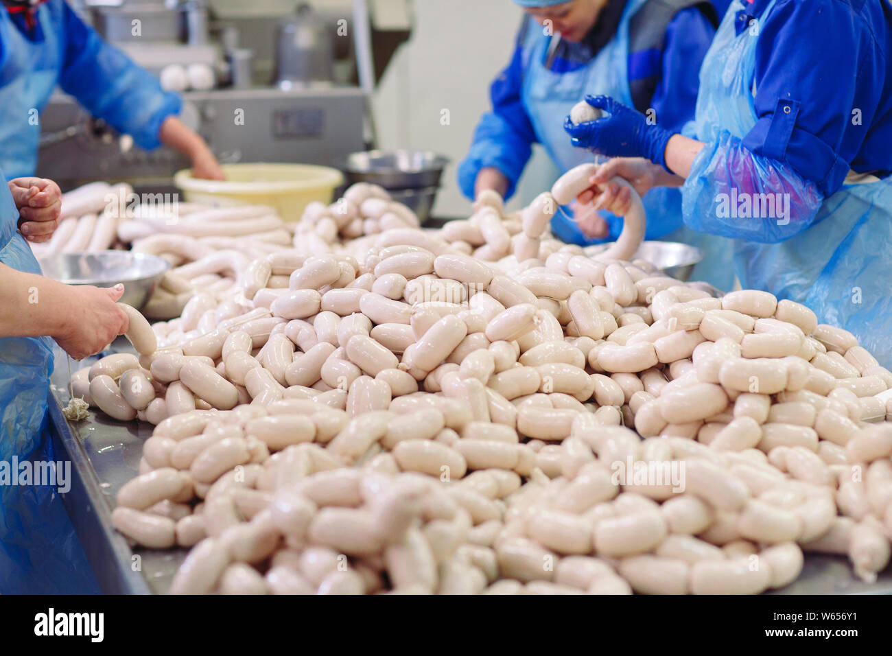 Butchers processing sausages at the meat factory Stock Photo - Alamy