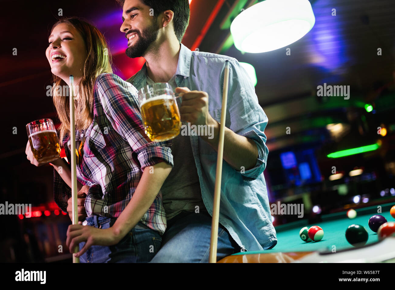 Couple drinking beer and playing snooker on date Stock Photo - Alamy