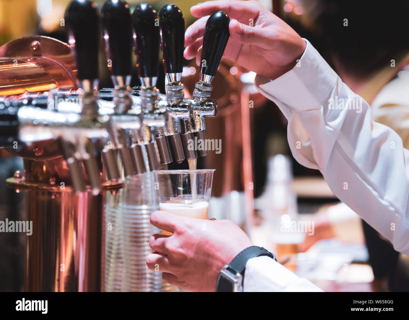 Bartender pouring draft beer in the bar, Barman hand at beer tap ...