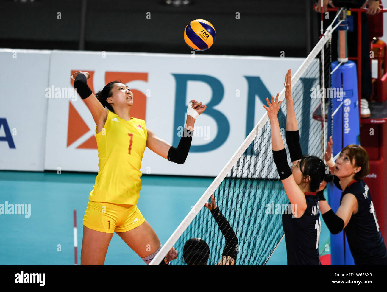 Yuan Xinyue of China, left, spikes against players of South Korea in ...