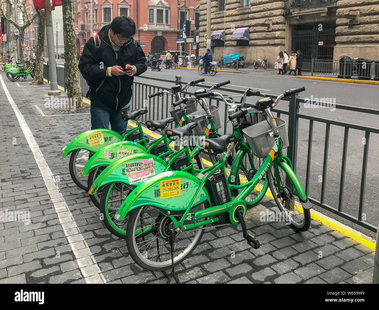 --FILE--A Chinese resident uses his smartphone to scan the QR code on a ...