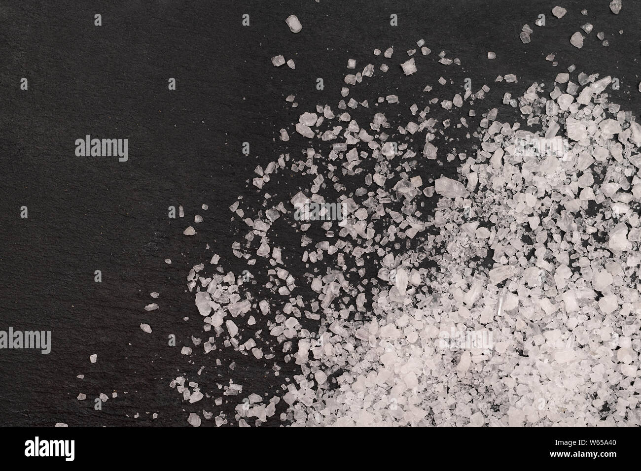 Spilled white sea salt isolated black background Stock Photo - Alamy