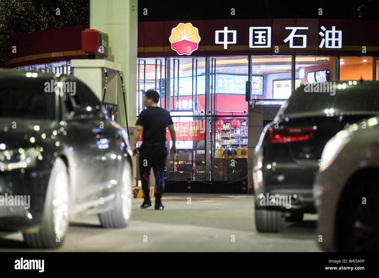 --FILE--Chinese citizens get their cars refueled at a gas station of ...