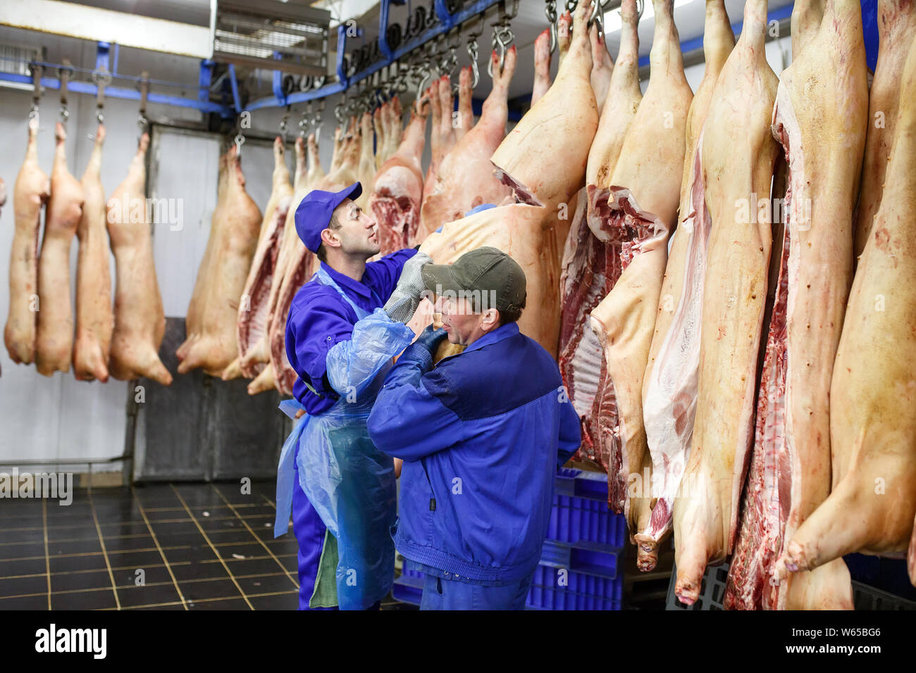 Butcher cutting pork at the meat manufacturing Stock Photo - Alamy