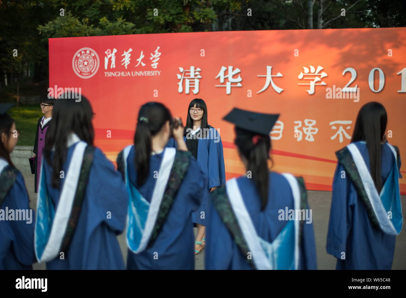 --FILE--Chinese graduates dressed in academic robes and hat pose for ...