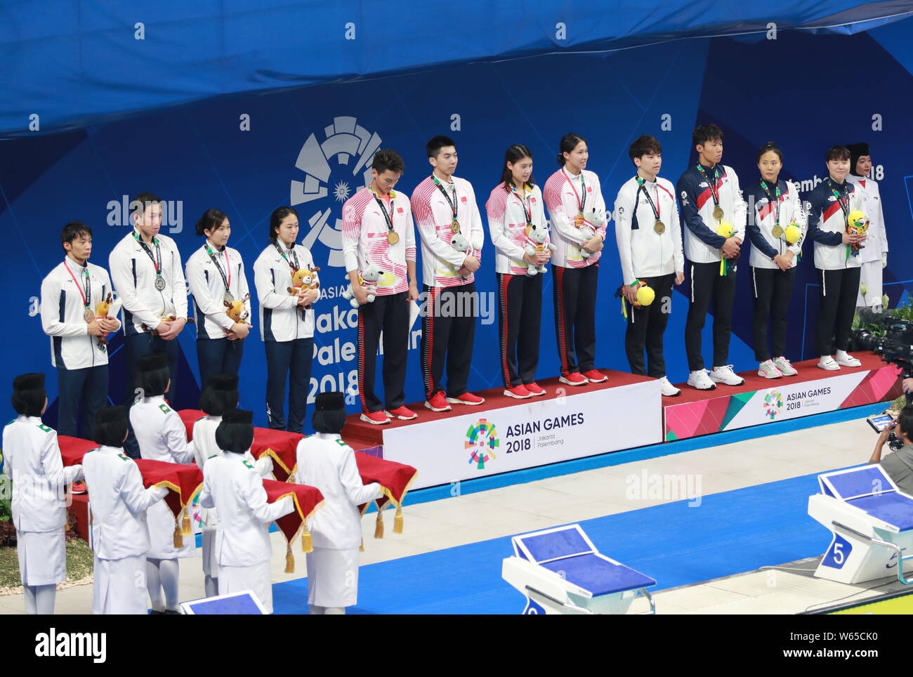 Gold medalist China's mixed 4x100 medley relay team, center, pose at ...