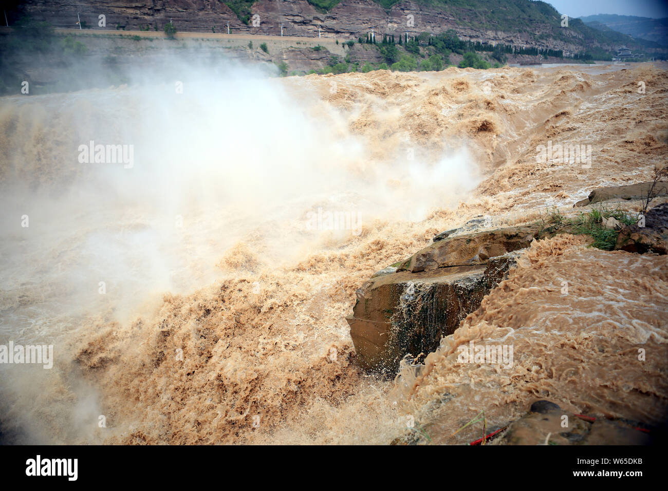 Tourists enjoy the scenes of the roaring waterfall due to torrential ...