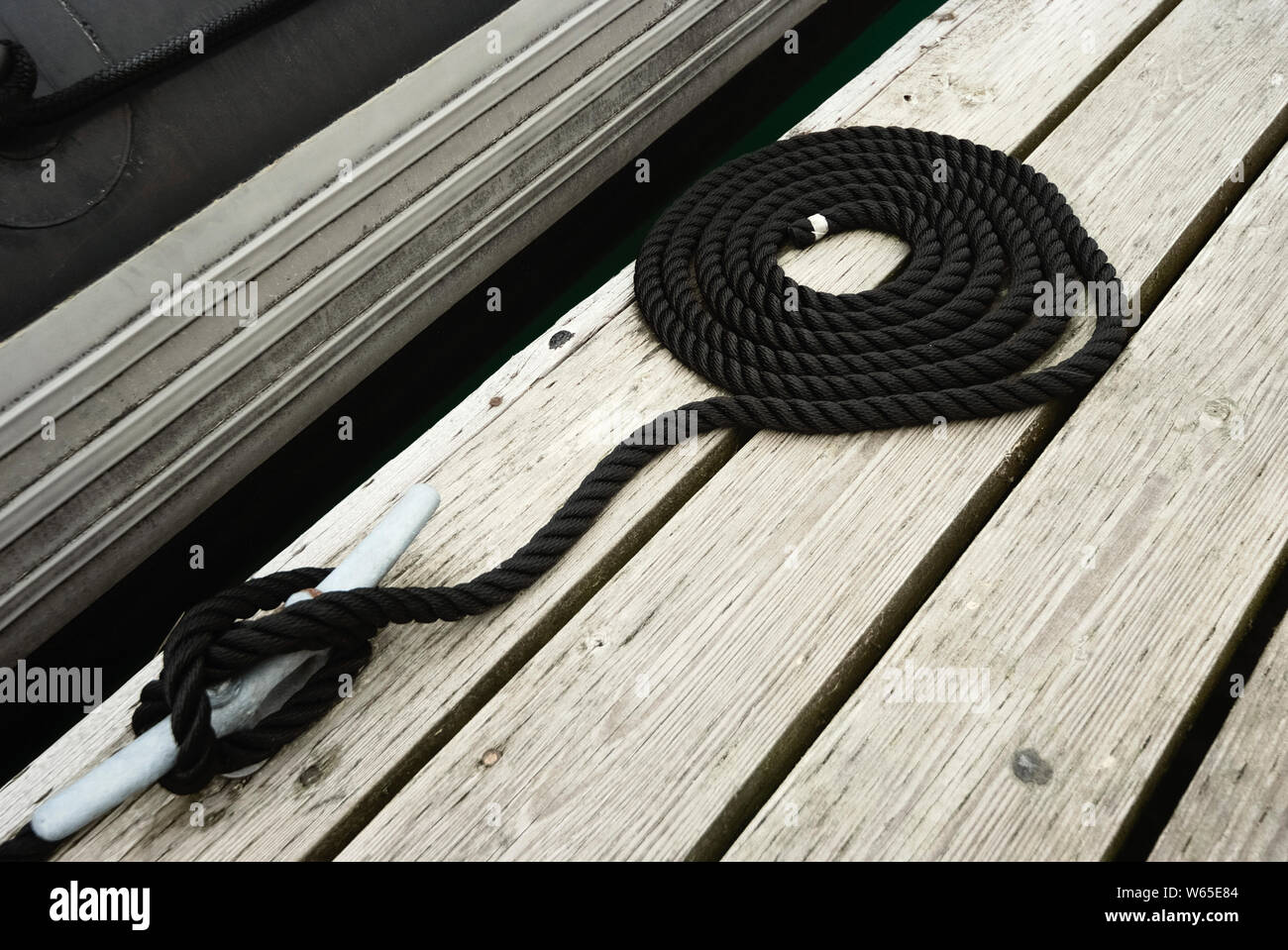 Black Swirled Mooring Rope Tied Up On A Bitt Securing Boat To Jetty ...