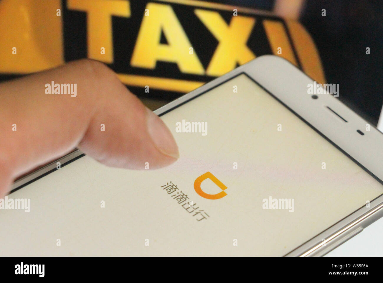 --FILE--A local Chinese resident uses the mobile app of taxi-hailing ...