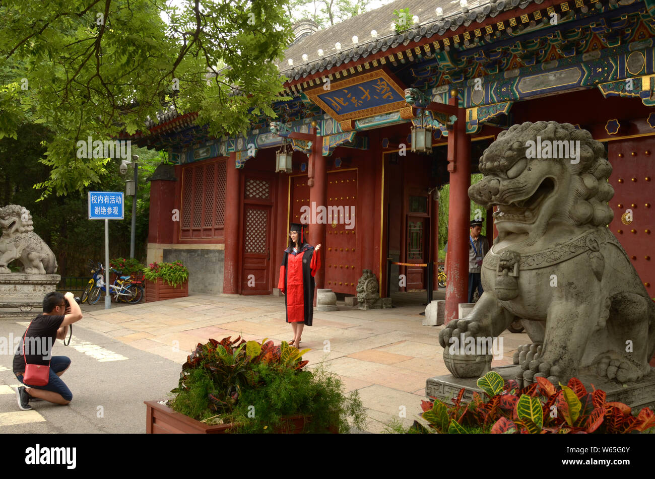 --FILE--A Chinese graduate dressed in doctoral gown and hat poses for ...