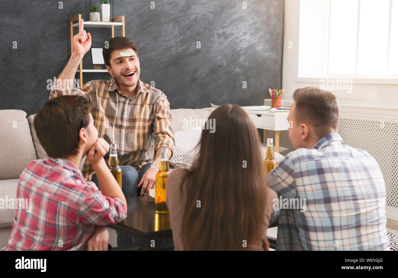 Company of friends playing forehead game at home Stock Photo - Alamy