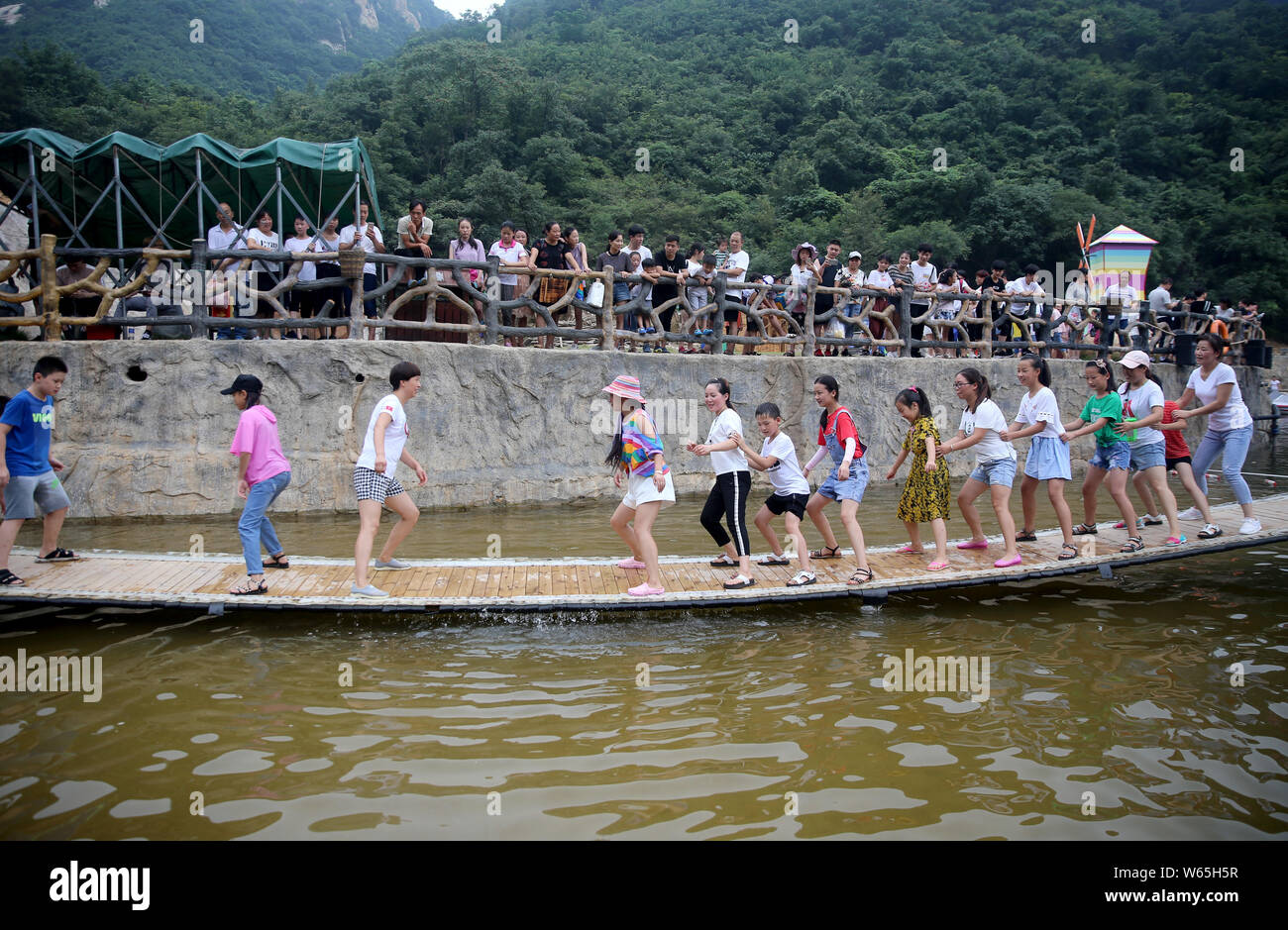 Holidaymakers try to keep balance as they wag side to side on a wonky ...