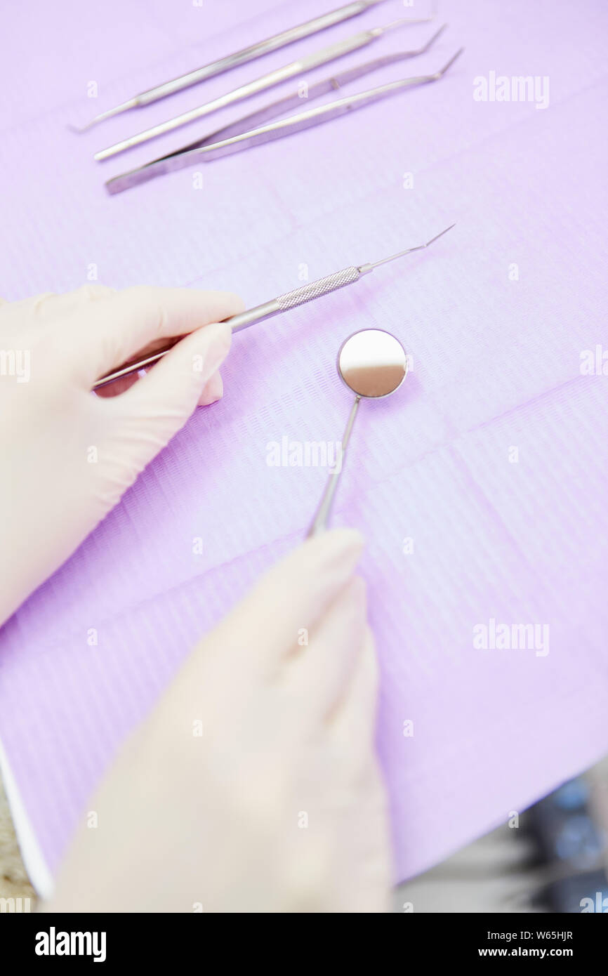 Gloves hold various hand instruments in the diagnostics of dentistry ...