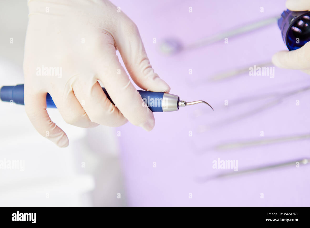 Dentist with glove holds a probe as an instrument or hand instrument of ...