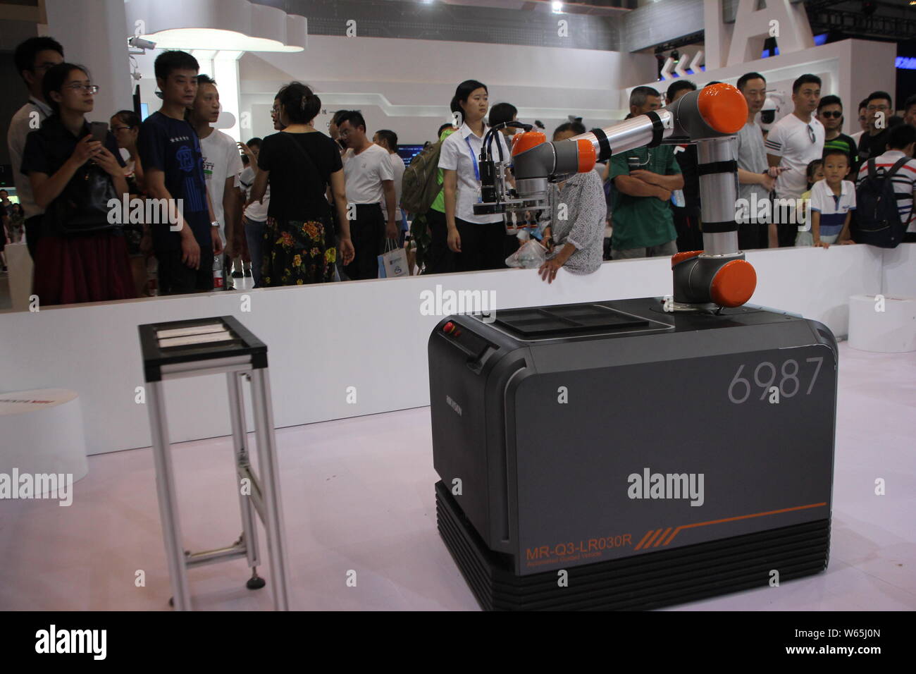 An AI-powered porter robot equipped with a mechanical arm developed by ...