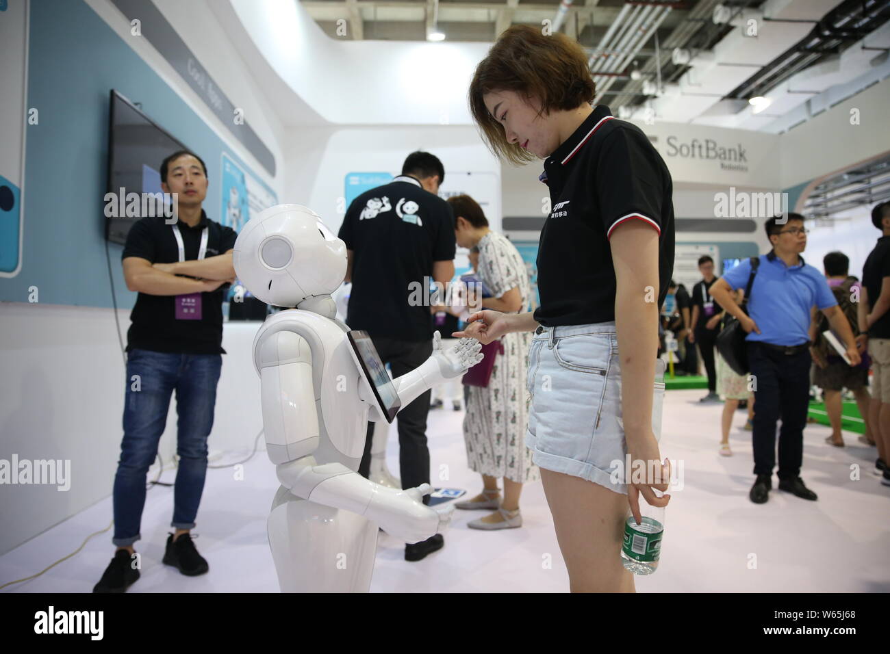 A visitor interacts with Pepper, a semi-humanoid robot manufactured by ...