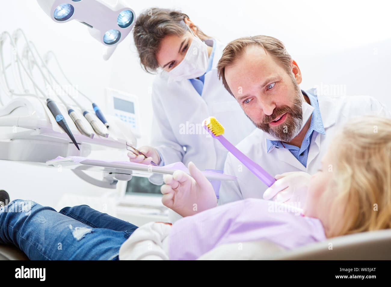 Pediatric dentist explains to child with a large toothbrush healthy ...