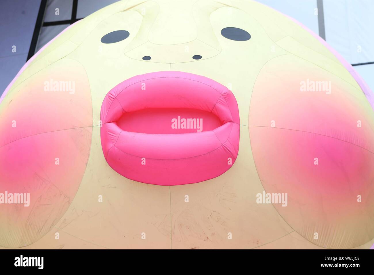 A six-meter-tall Kobitos sculpture is on display during a special ...