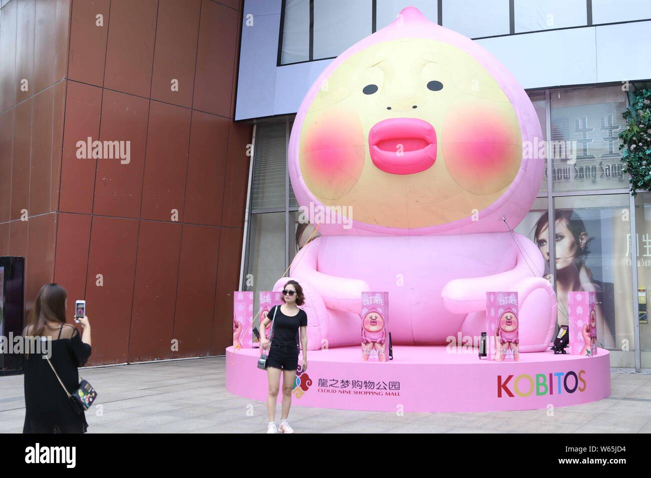 A six-meter-tall Kobitos sculpture is on display during a special ...
