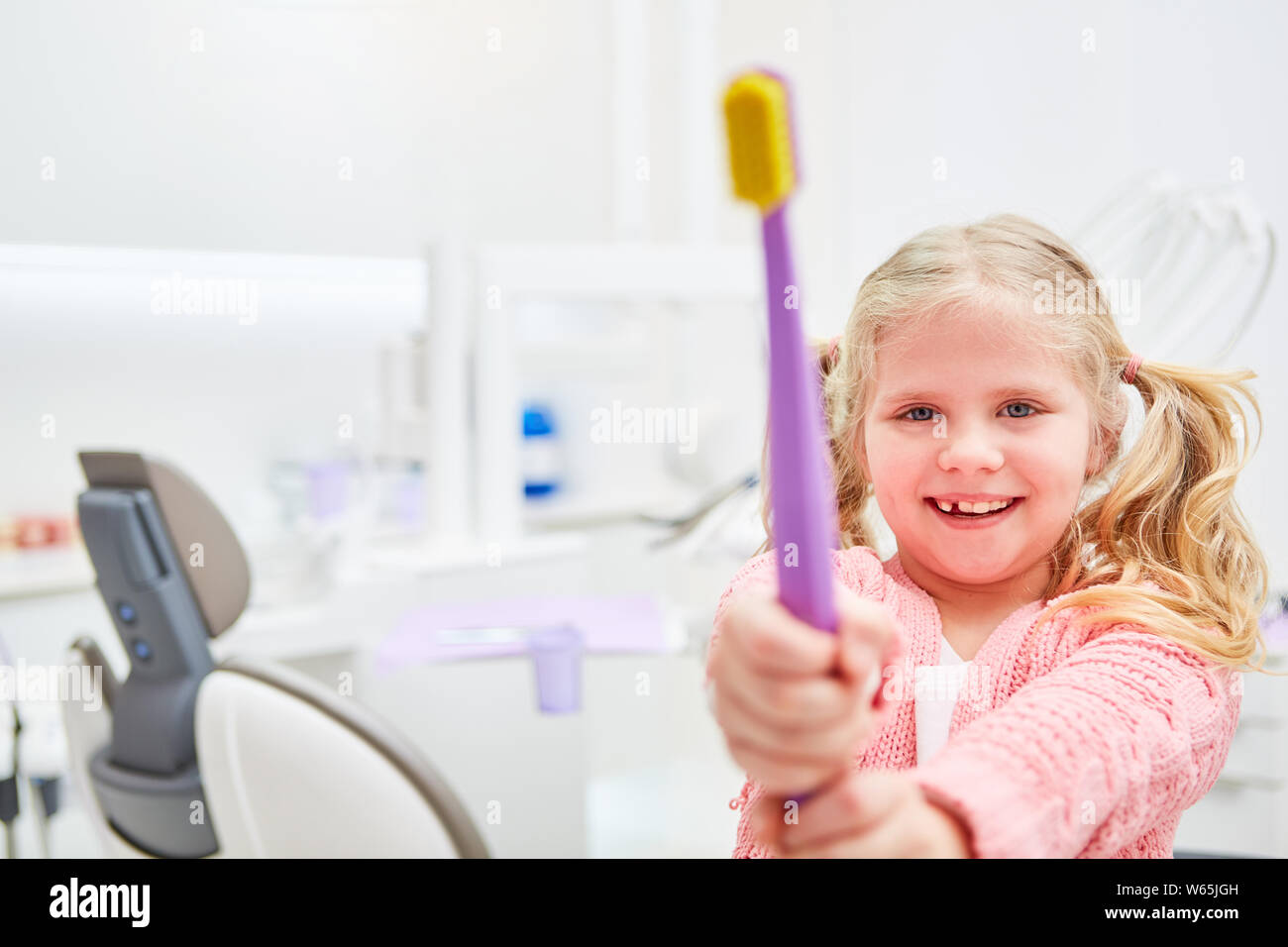 Smiling child with a giant toothbrush symbolizing teeth brushing as ...