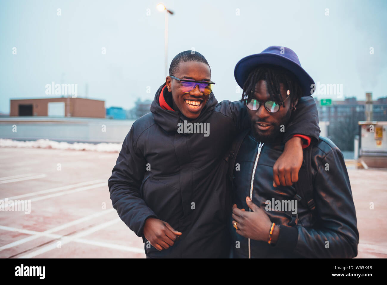 two young african men posing together in the street and looking camera ...
