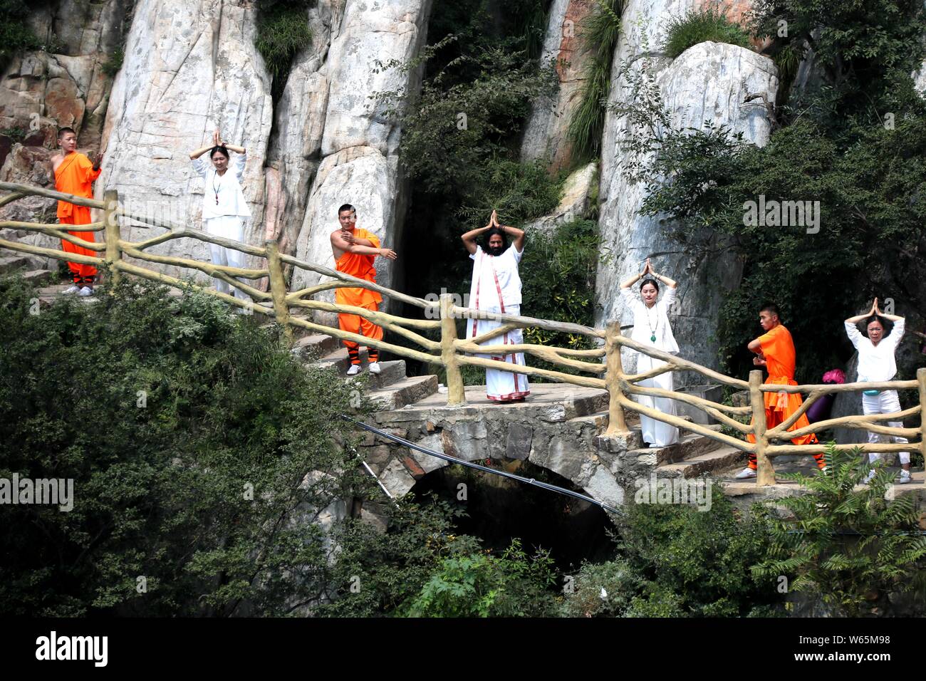 In this aerial view, Yoga lovers practice yoga and Shaolin students ...