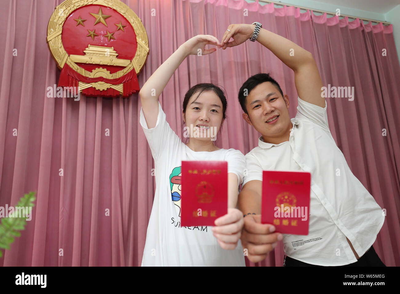 A Chinese couple shows their marriage certificates at a civil affairs ...