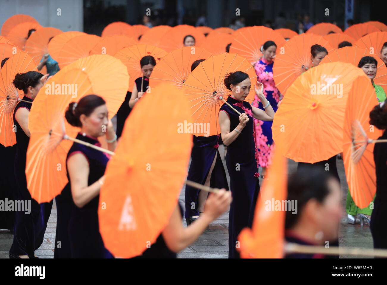 Chinese women dressed in cheongsam, also known as qipao in Chinese ...