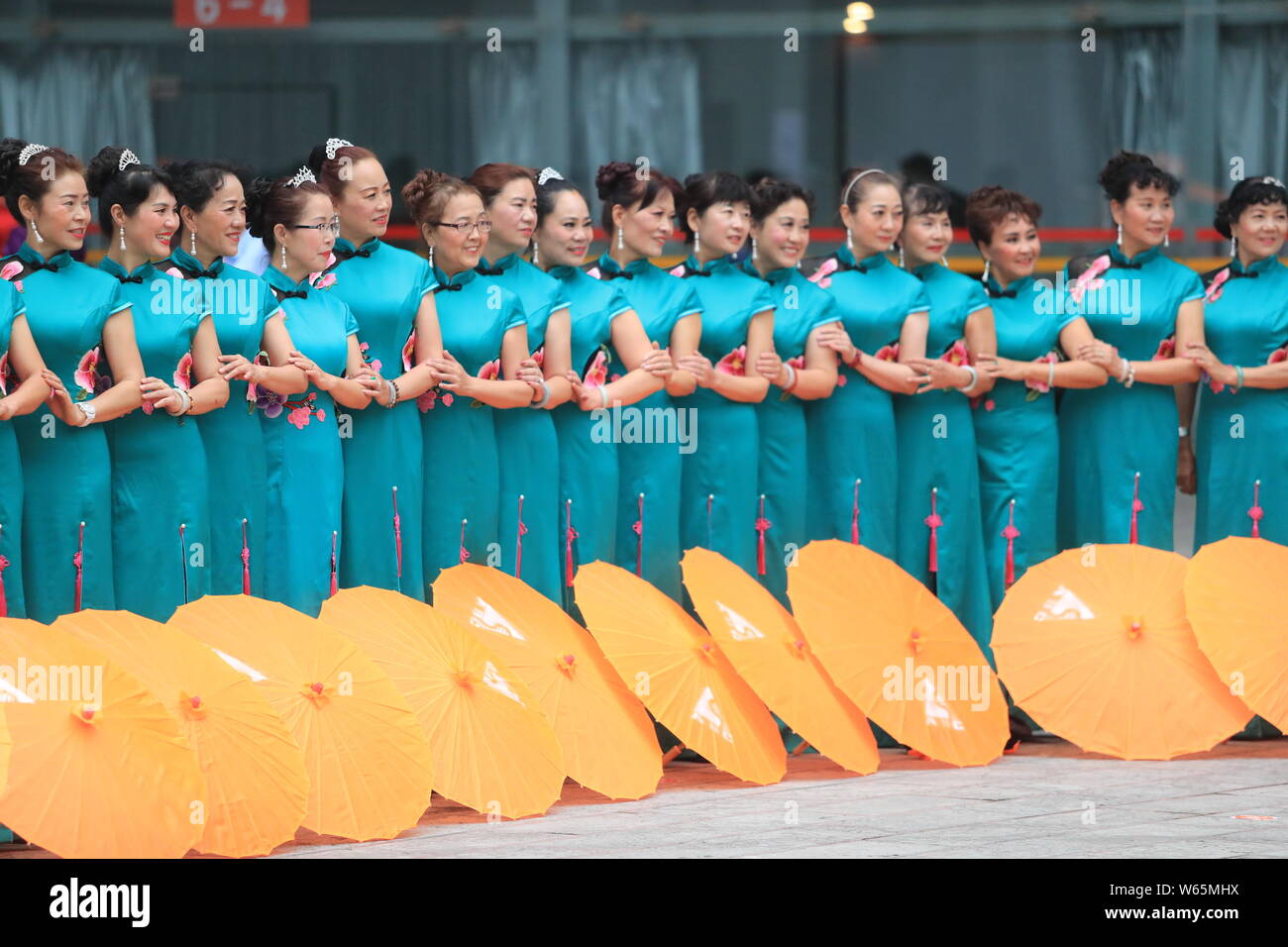 Chinese women dressed in cheongsam, also known as qipao in Chinese ...