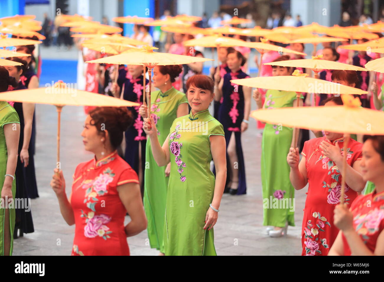 Chinese women dressed in cheongsam, also known as qipao in Chinese ...