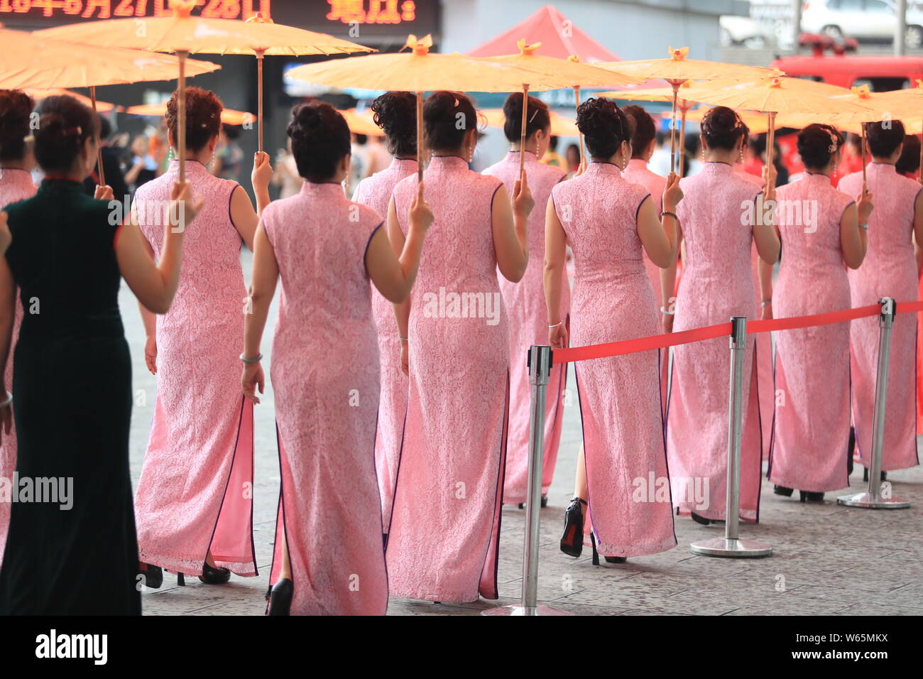Chinese women dressed in cheongsam, also known as qipao in Chinese ...