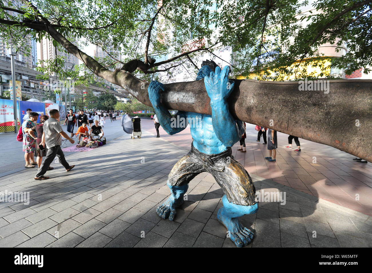 A giant "hulk" sculpture lifts a tree trunk on the Yangjiaping street ...