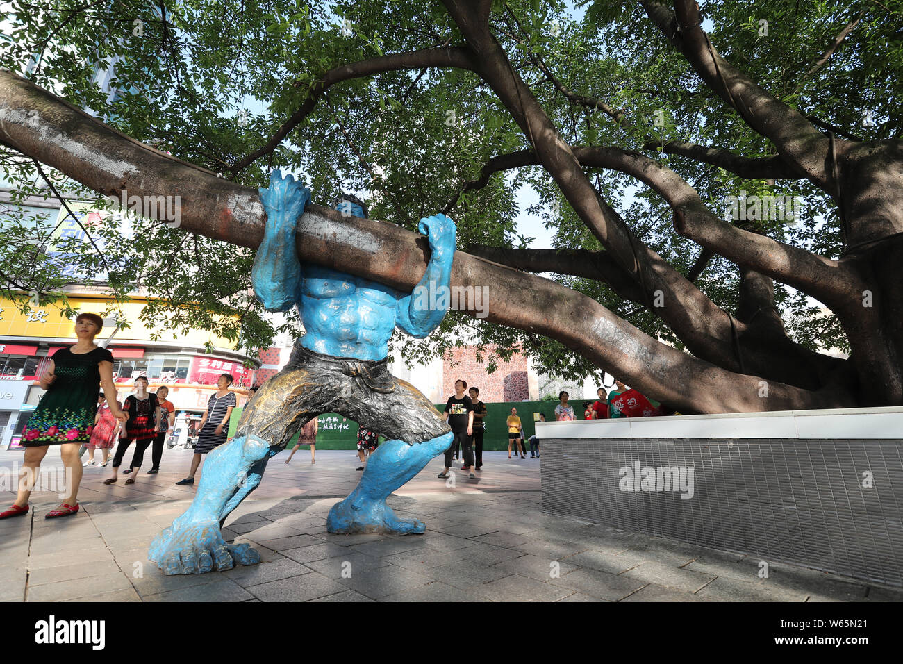 A giant "hulk" sculpture lifts a tree trunk on the Yangjiaping street ...