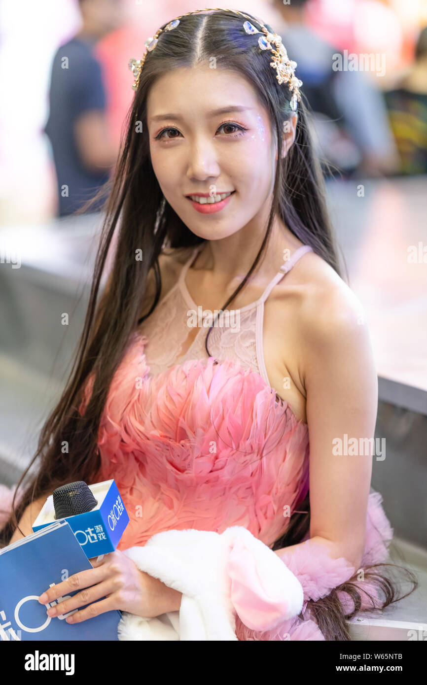 A Chinese showgirl poses at the stand of Migu Games during the 16th ...