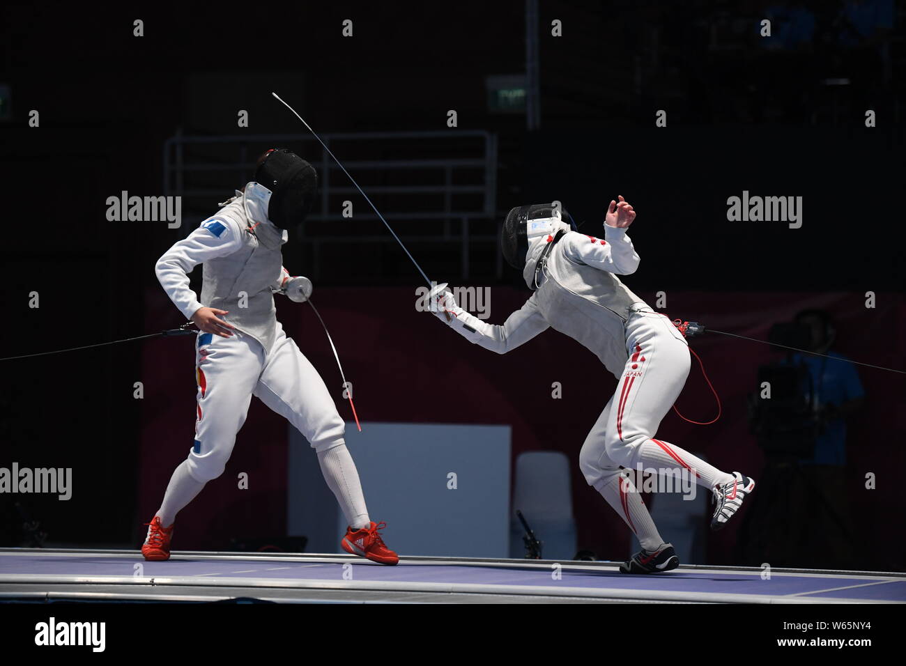 Players of Japan's foil team and China's foil team compete in their ...