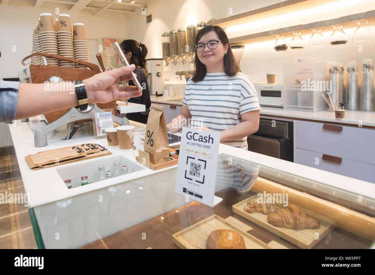 A customer uses his smartphone to scan the QR code to pay via the ...