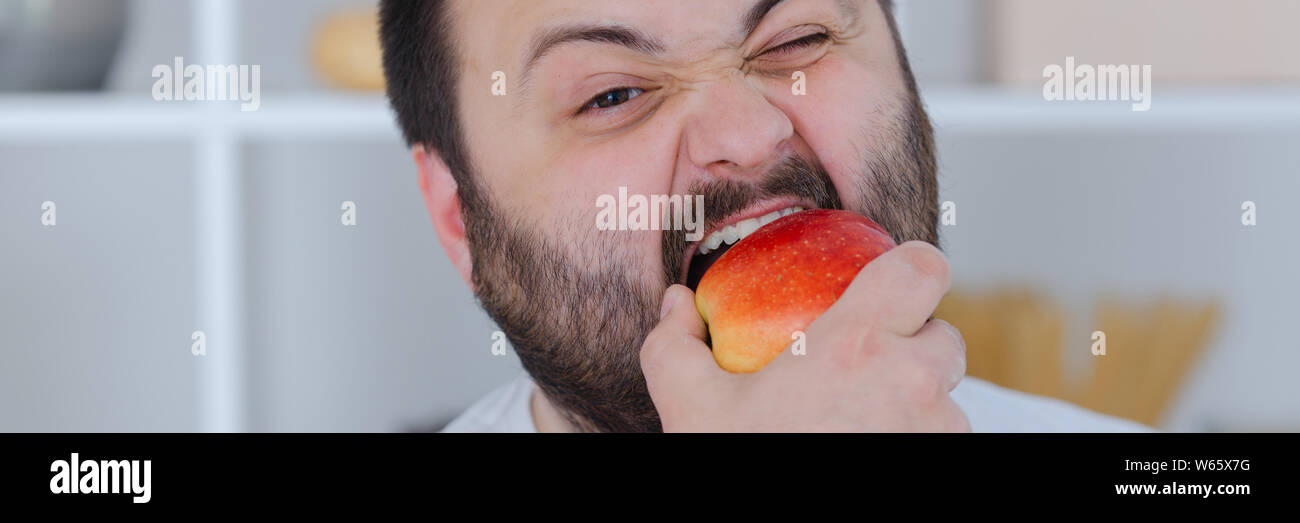 Attractive male biting apple Stock Photo - Alamy