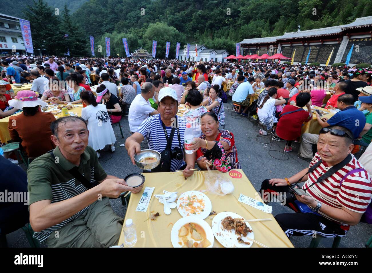 Thousands of tourists eat dinner around tables during a free-flowing ...