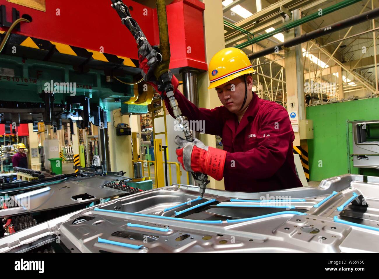 --FILE--A Chinese worker assembles a truck on the assembly line at the ...
