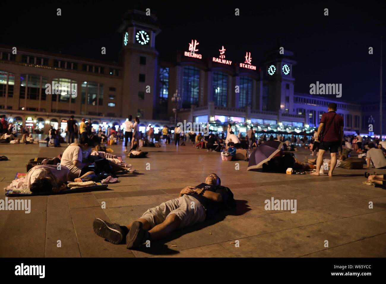 Chinese passengers sleep and wait for their trains at the square of ...