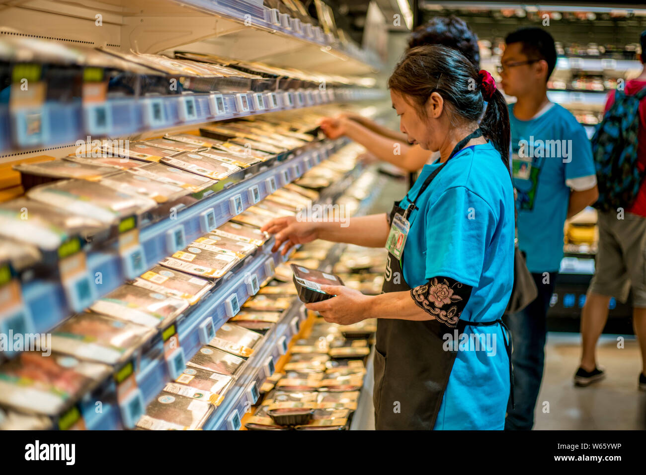 --FILE--Chinese employees work at a store of O2O fresh produce retailer ...