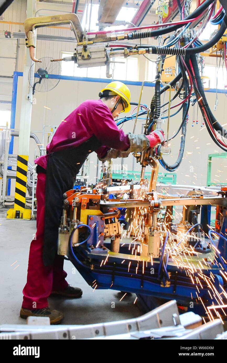 --FILE--A Chinese worker assembles a truck on the assembly line at the ...