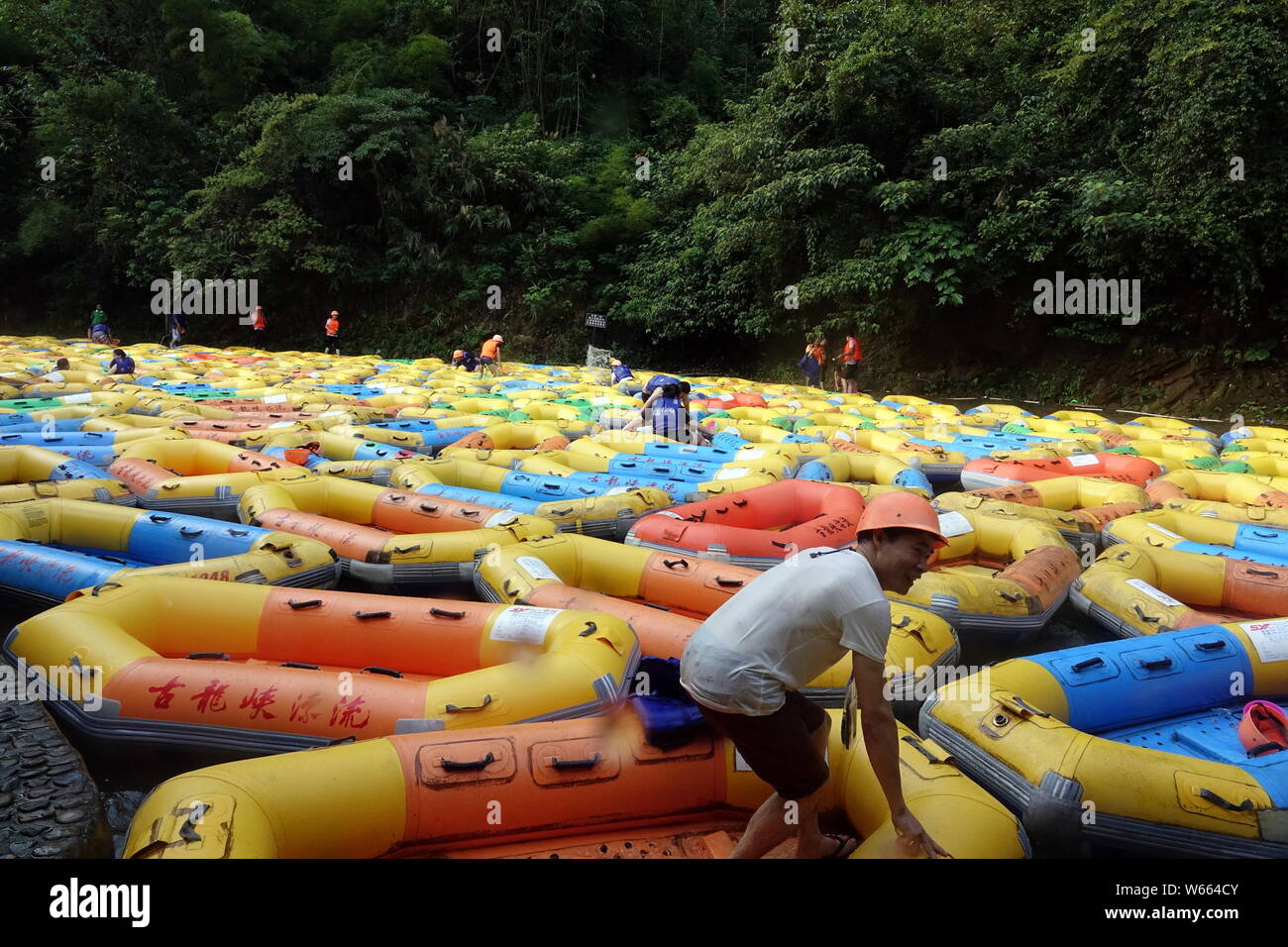 A crowd of tourists sitting on inflatable rafts jam Gulong Valley as ...