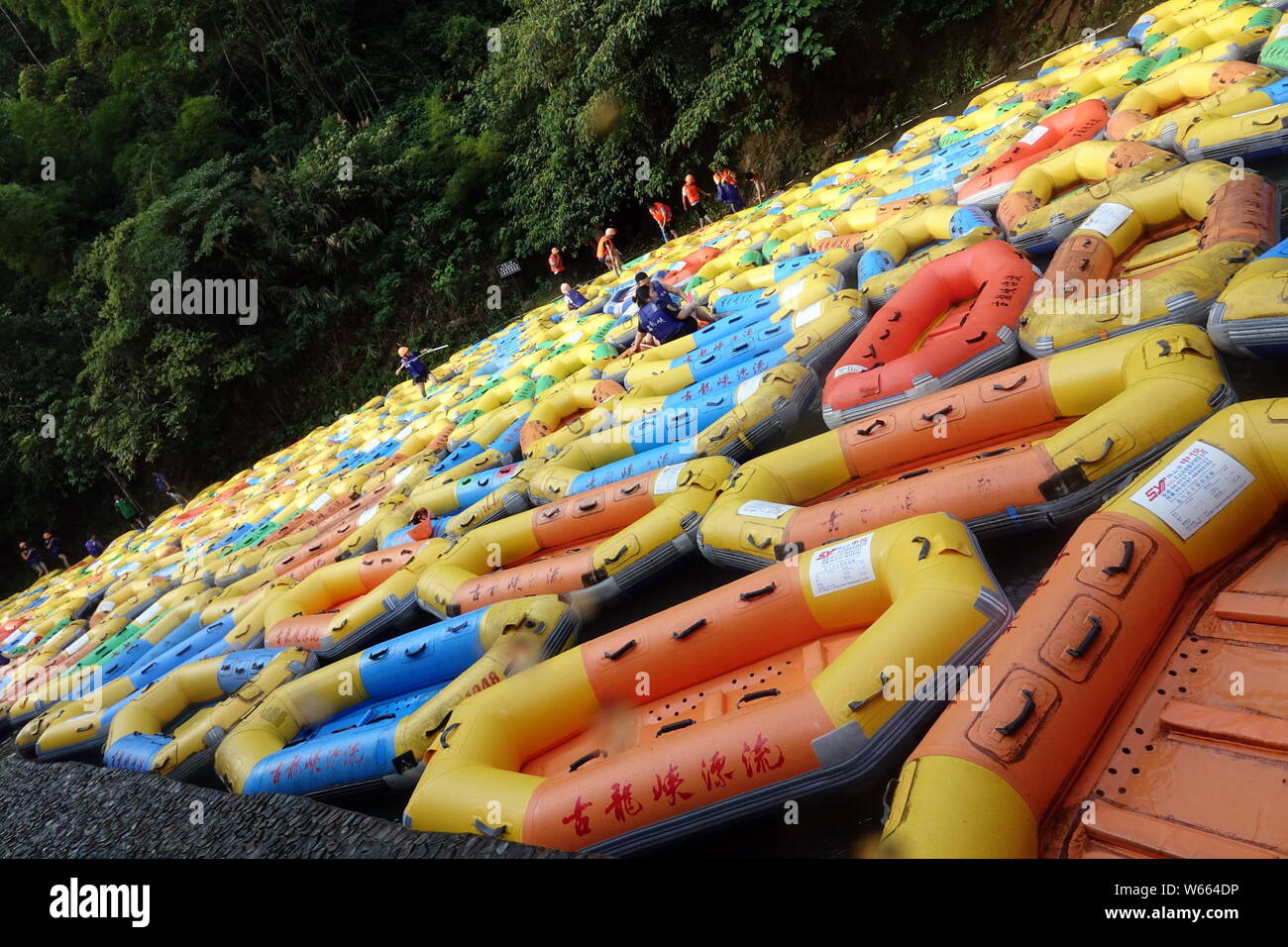 A crowd of tourists sitting on inflatable rafts jam Gulong Valley as ...