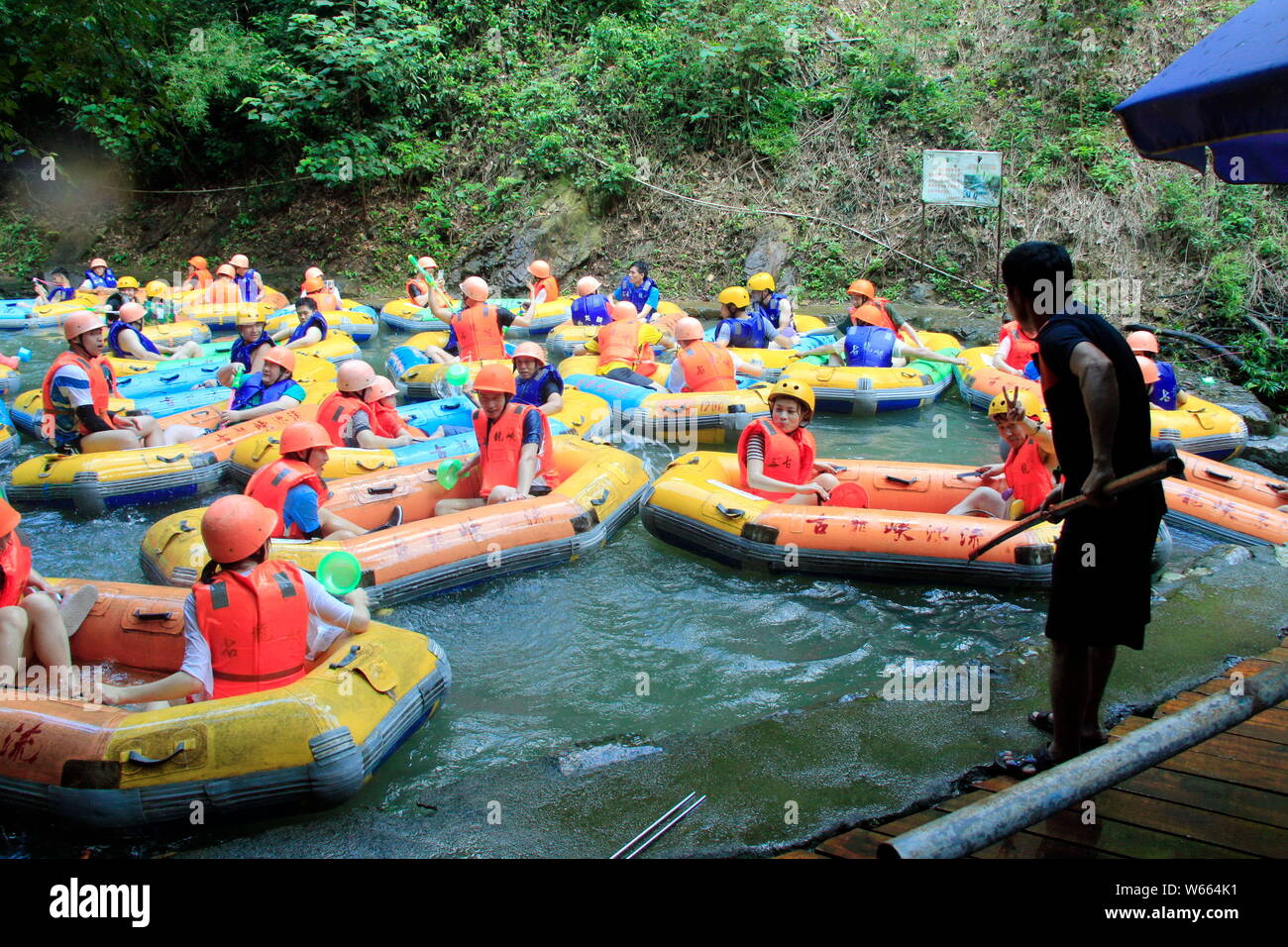 A crowd of tourists sitting on inflatable rafts jam Gulong Valley as ...