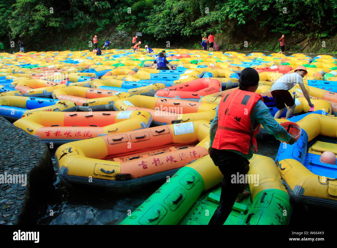 A crowd of tourists sitting on inflatable rafts jam Gulong Valley as ...